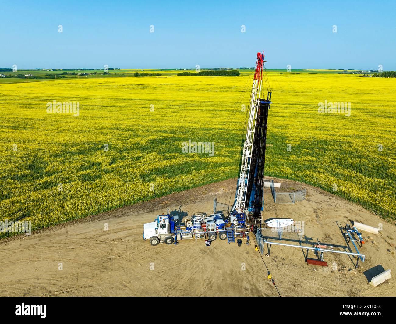 Aerial view of a drilling rig mounted on a truck in a flowering canola ...