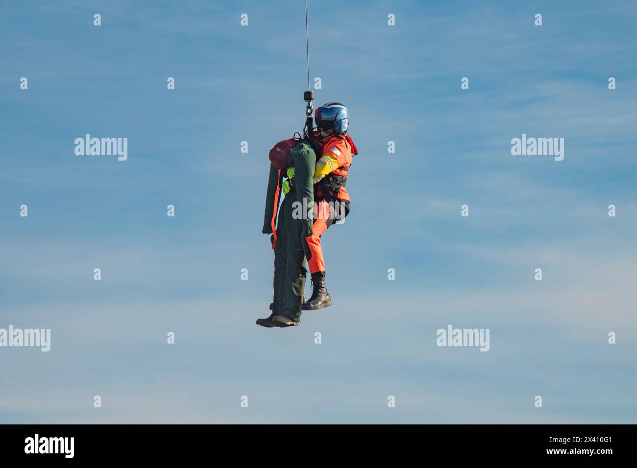 U. S. Coast Guard crewman suspended below a Sikorsky MH-60J Jayhawk ...