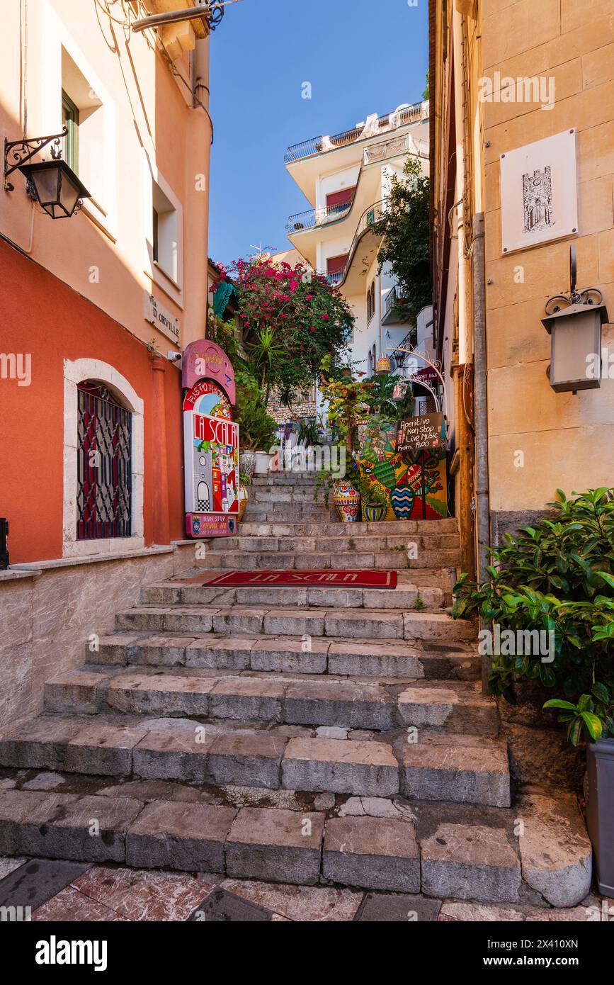 Stone steps on a walkway leading through a residential area in Taormina ...