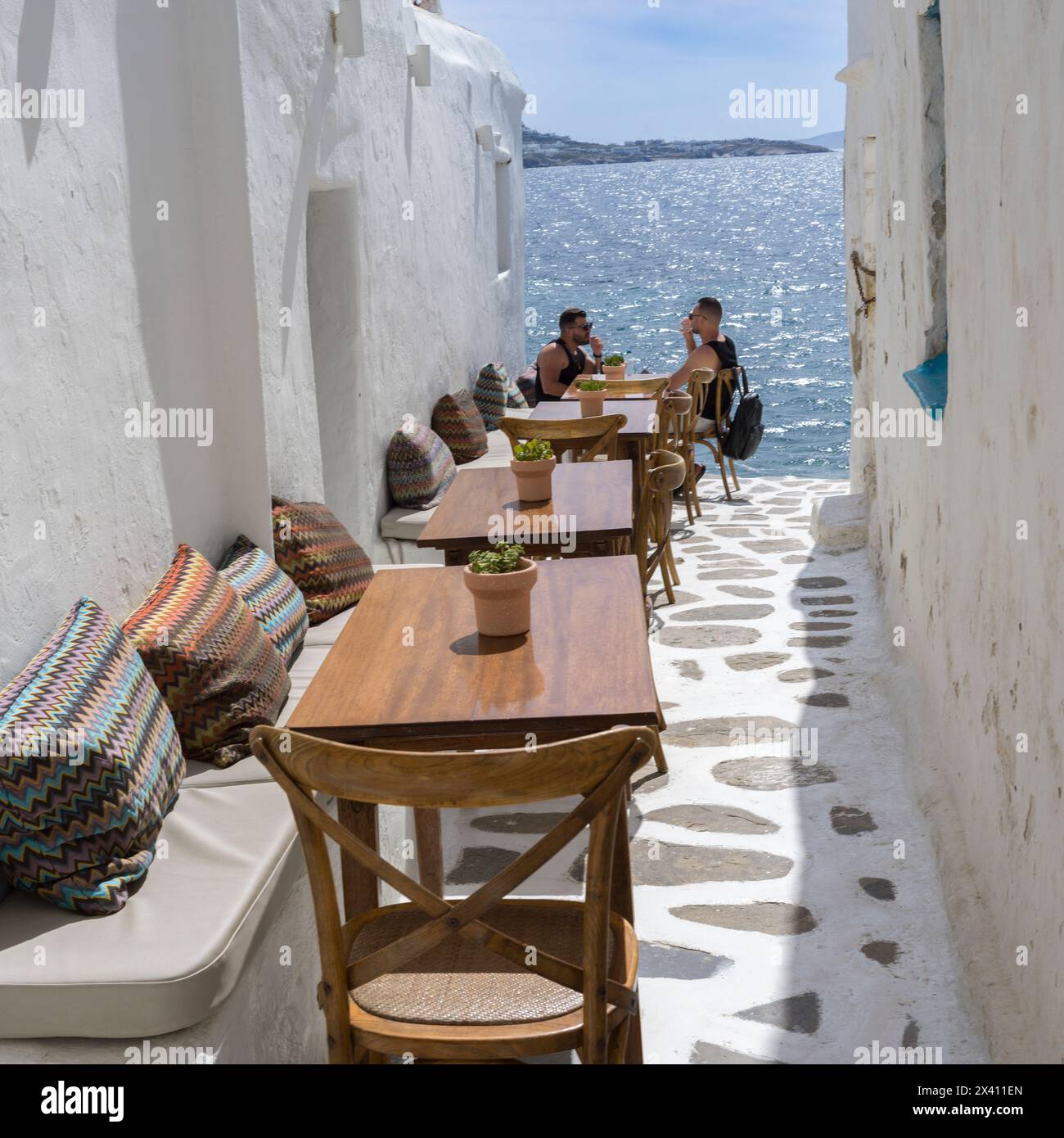 Two men enjoy a waterfront patio on the island of Mykonos; Mykonos ...