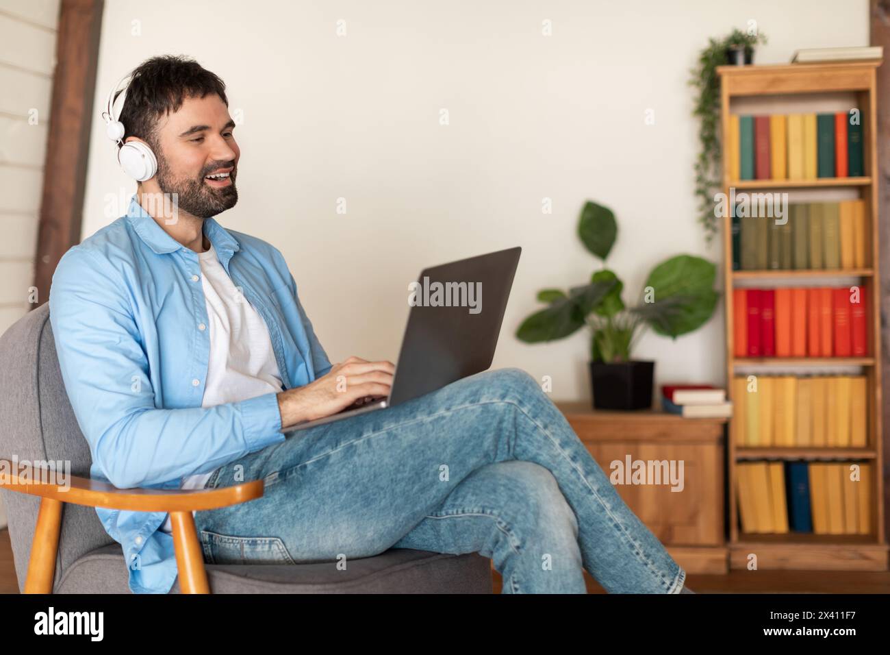 Man Sitting on Chair Using Laptop Computer And Headphones Stock Photo ...