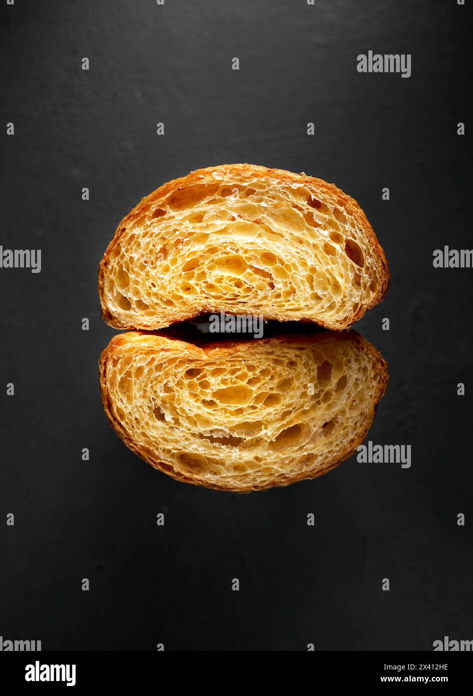 Doble Cross section of a croissant containing air on black background ...