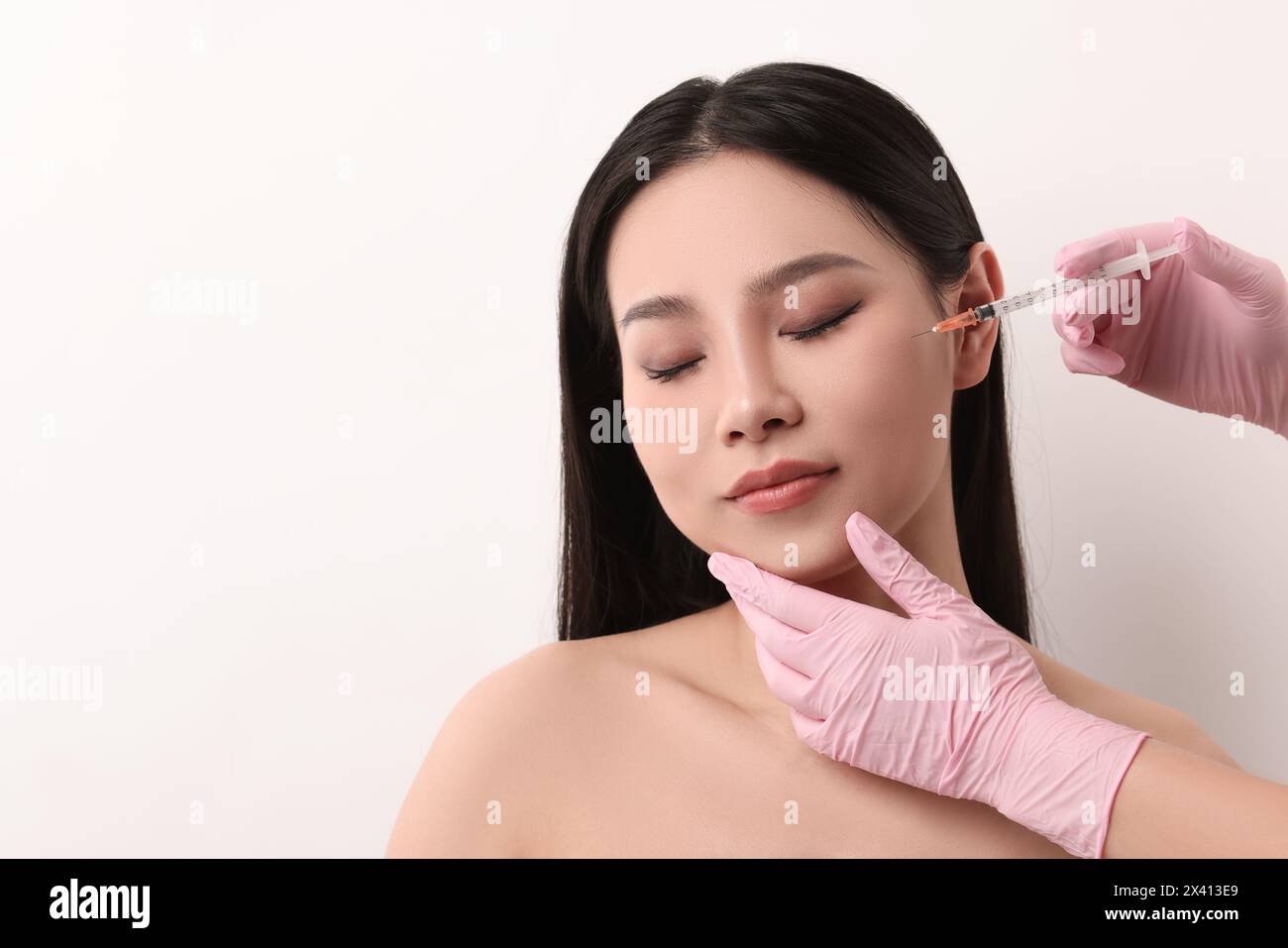 Woman getting facial injection on white background Stock Photo - Alamy