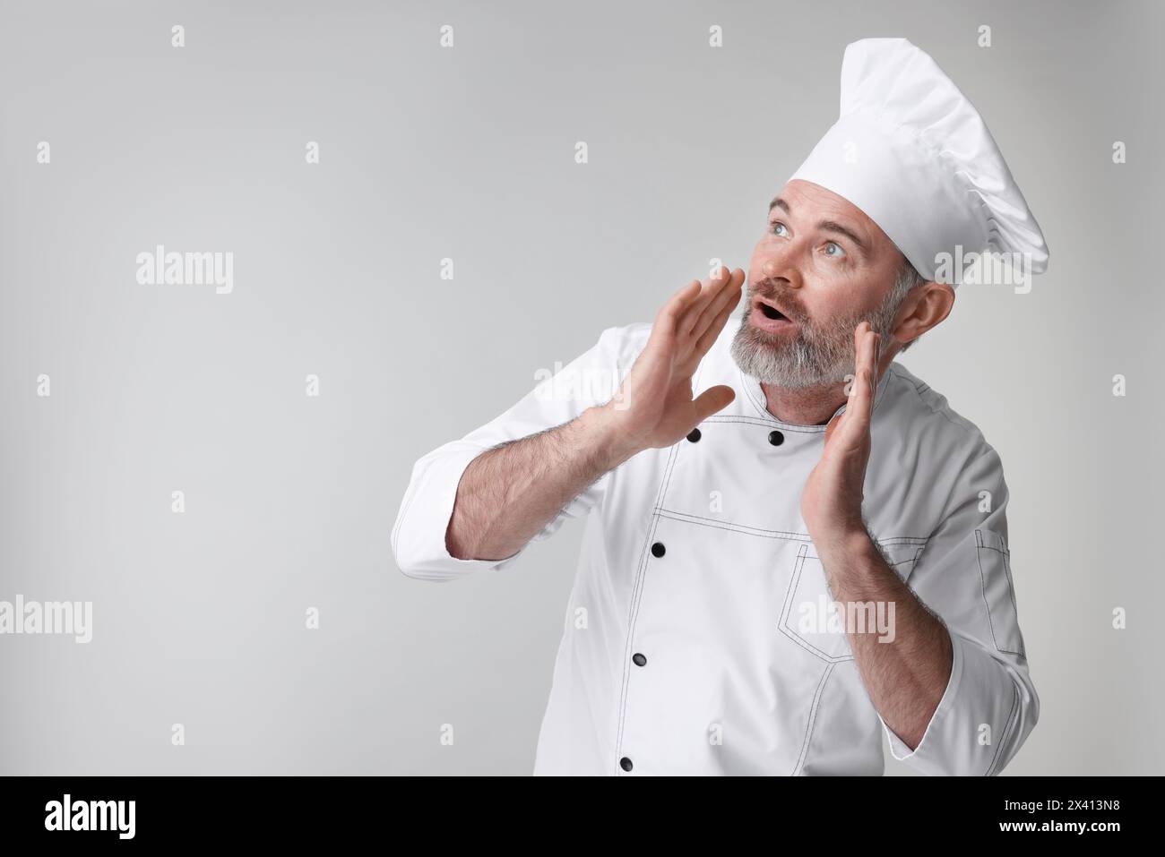 Surprised chef in uniform on grey background, space for text Stock ...