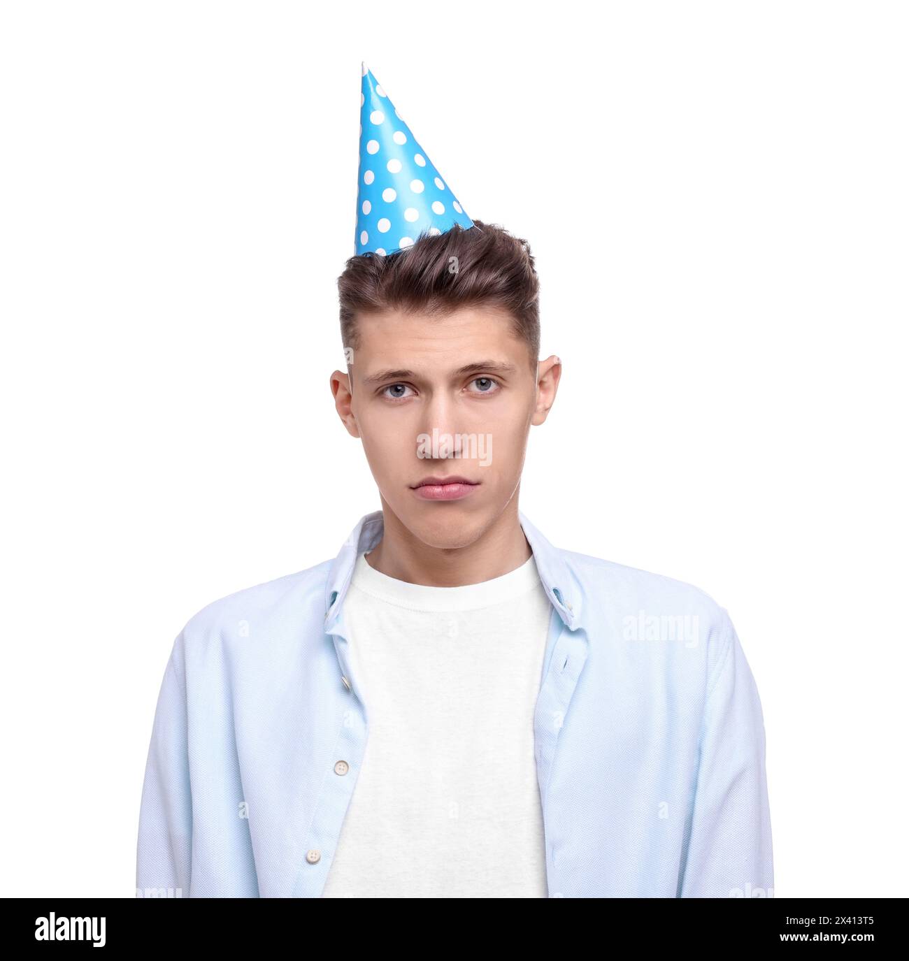 Sad young man in party hat on white background Stock Photo - Alamy