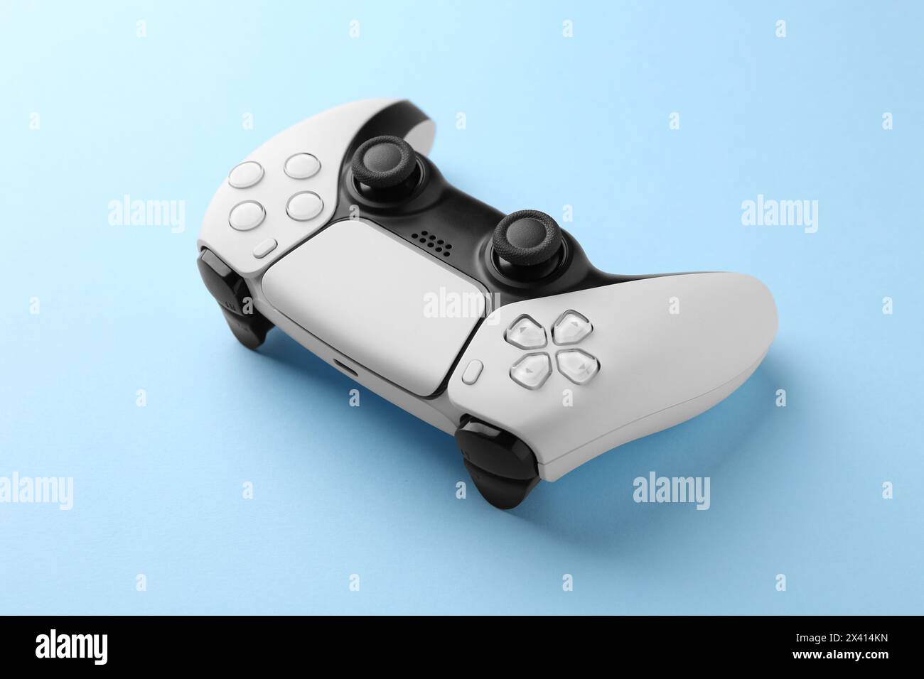 Wireless game controller on light blue background Stock Photo - Alamy