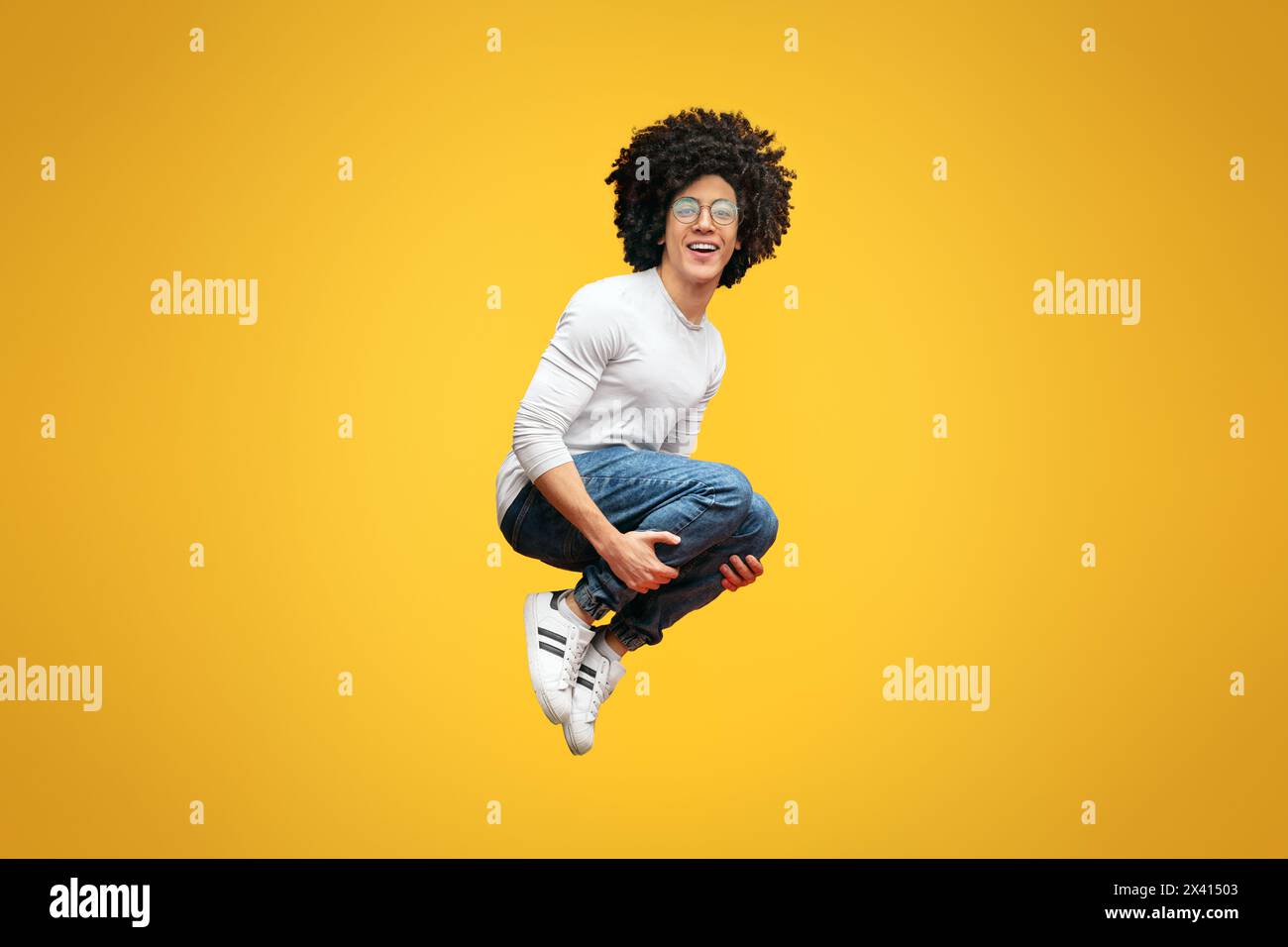 Cheerful millennial man jumping in bomb style Stock Photo - Alamy
