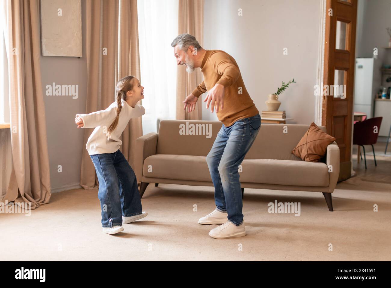 Grandfather Engaging in a Playful Dance With Young Granddaughter Stock ...