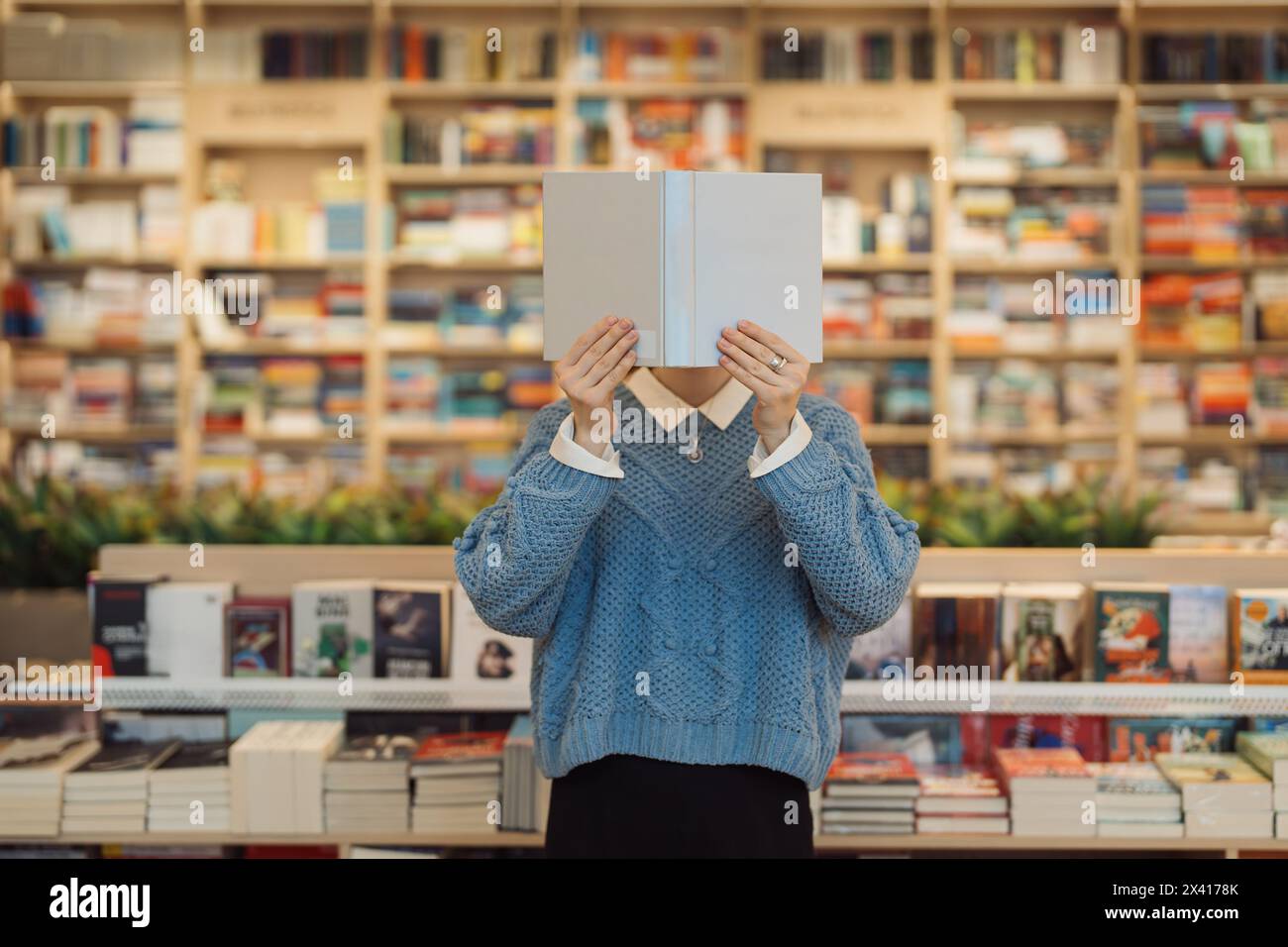 Woman reading a book in a cozy bookstore Stock Photo - Alamy