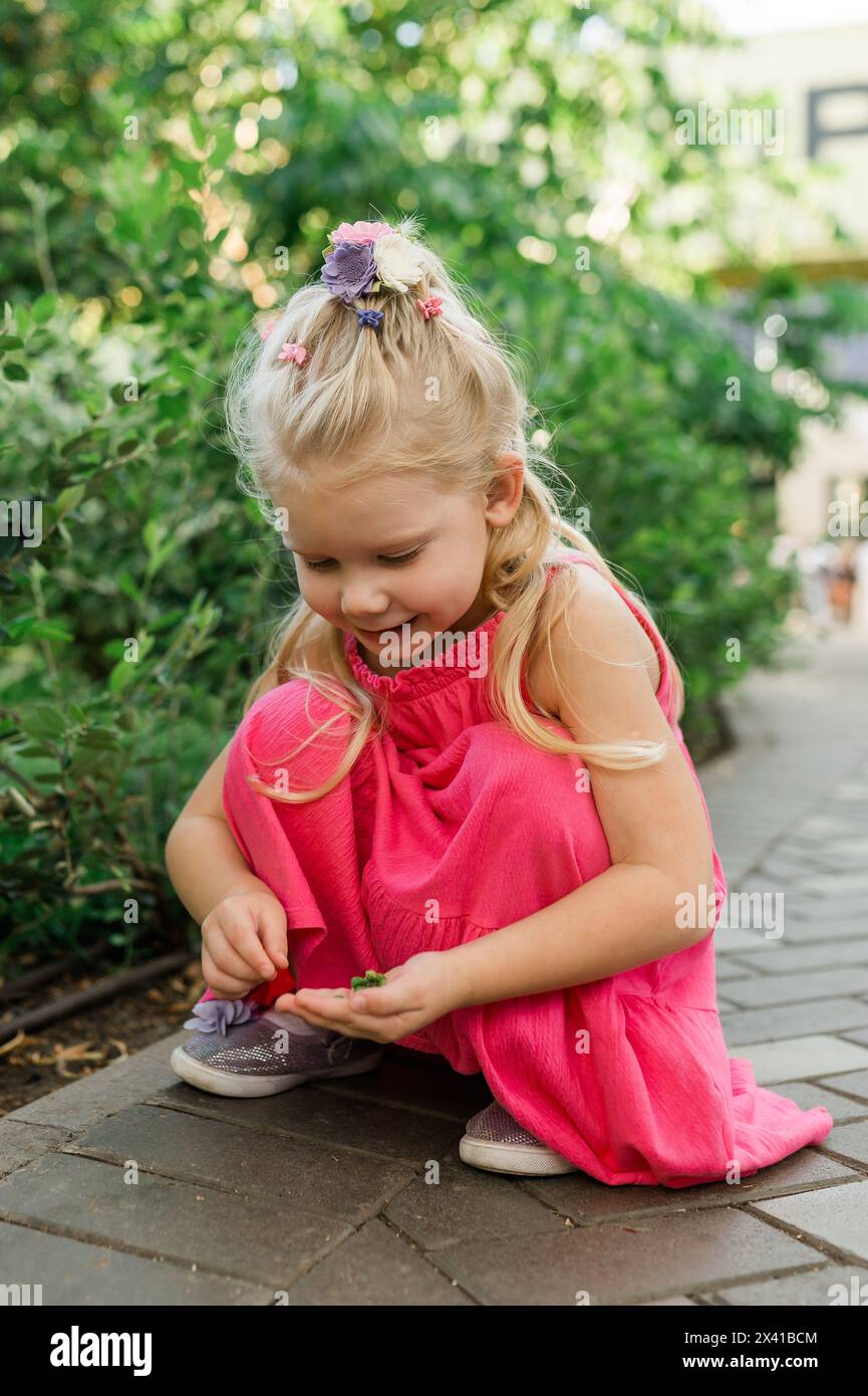 Child girl walks and have fun outdoor with cochlear implant on the head ...
