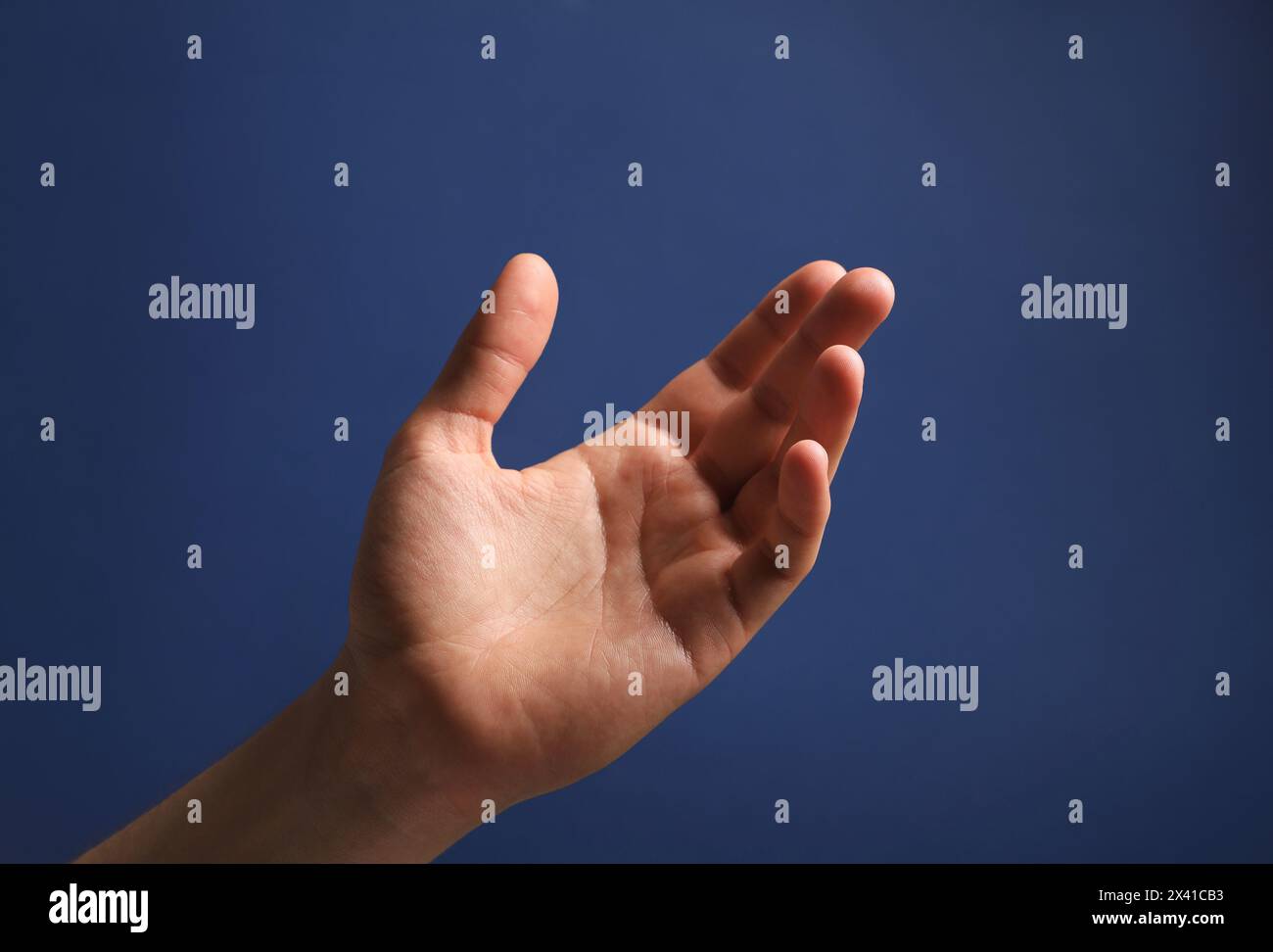 Man holding something in hand on blue background, closeup Stock Photo ...