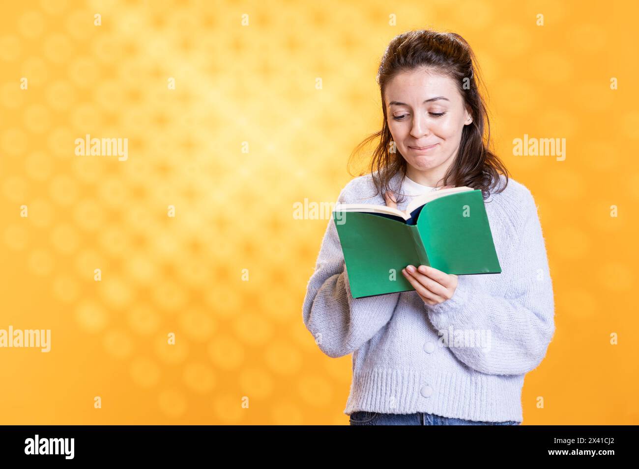 Woman laughing while reading funny book, enjoying hobby during leisure ...