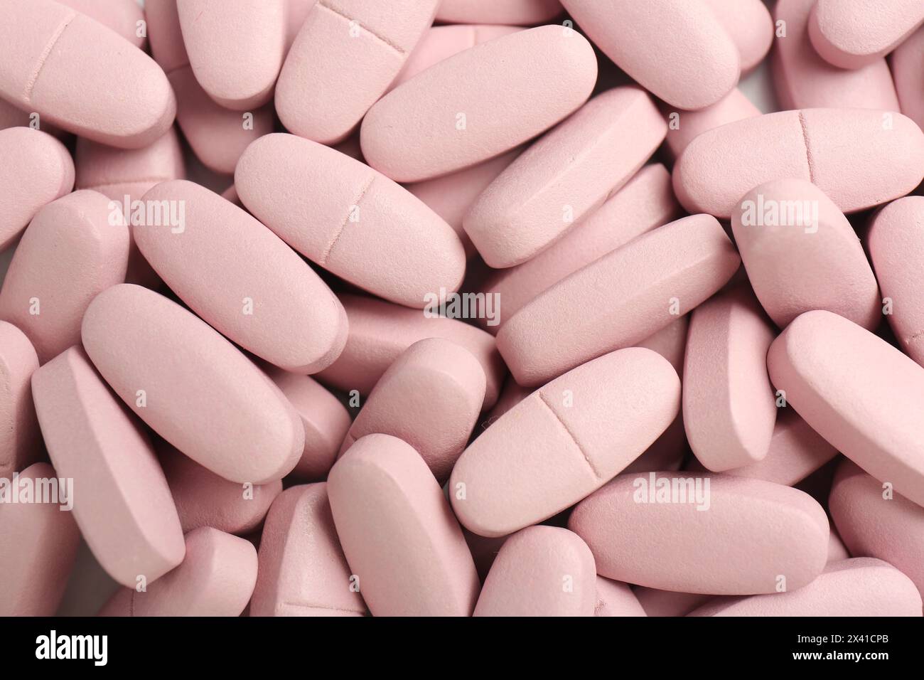 Pink vitamin capsules as background, top view Stock Photo - Alamy