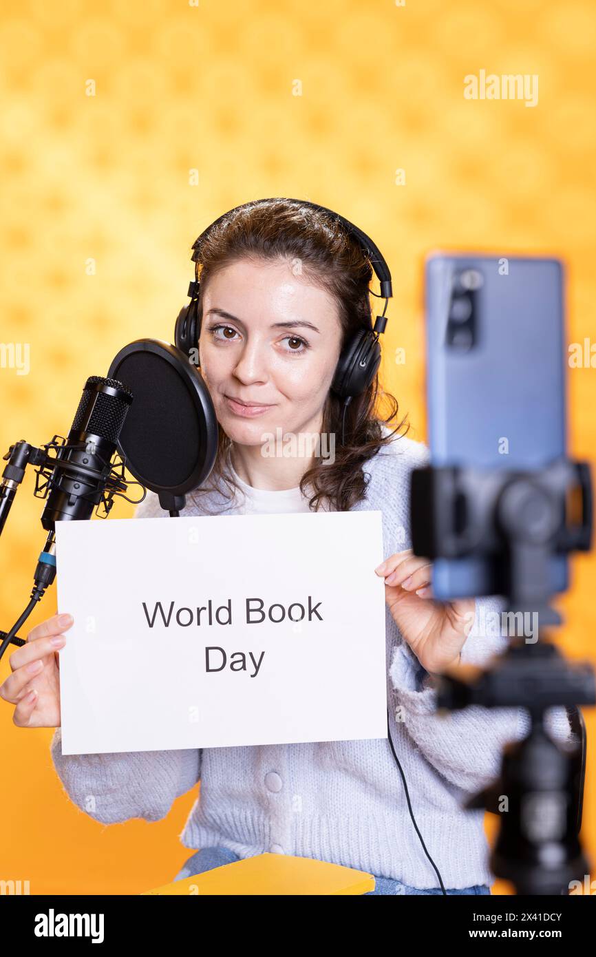 Woman filming promotional video for world book day using microphone and ...