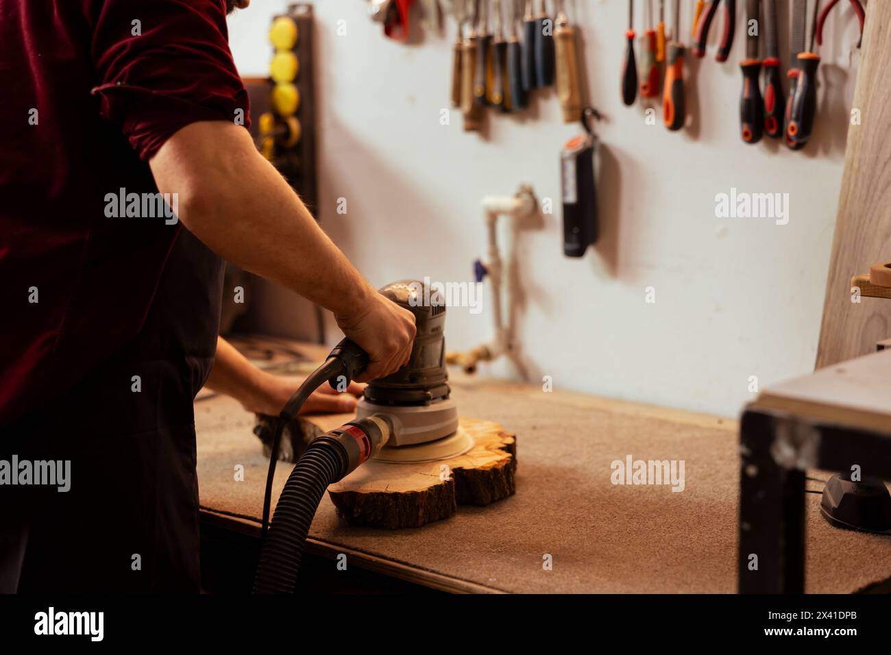 Carpenter using orbital sander with finer sandpaper grits to achieve ...