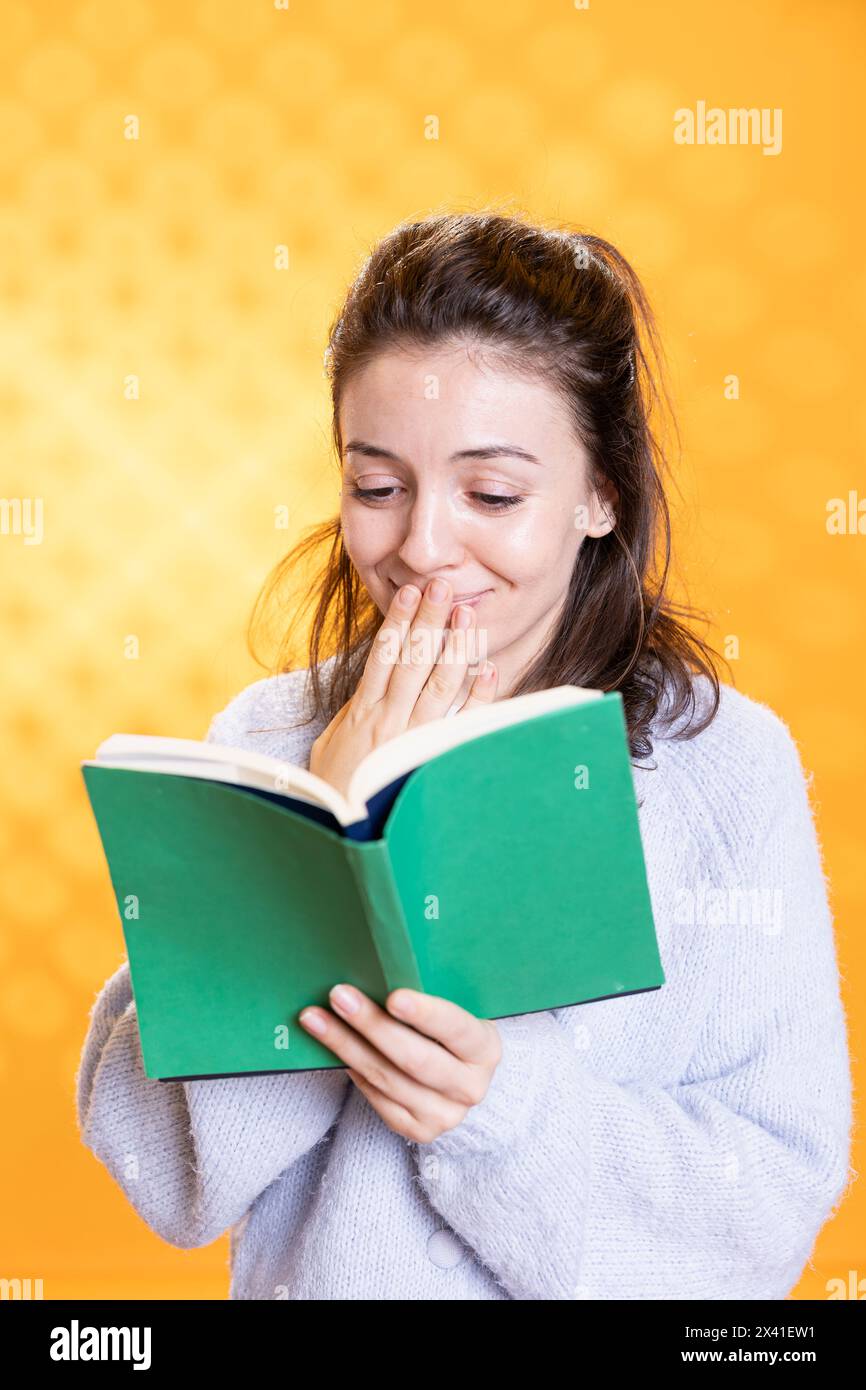 Woman amused by funny book, conveying joy of reading concept, isolated ...