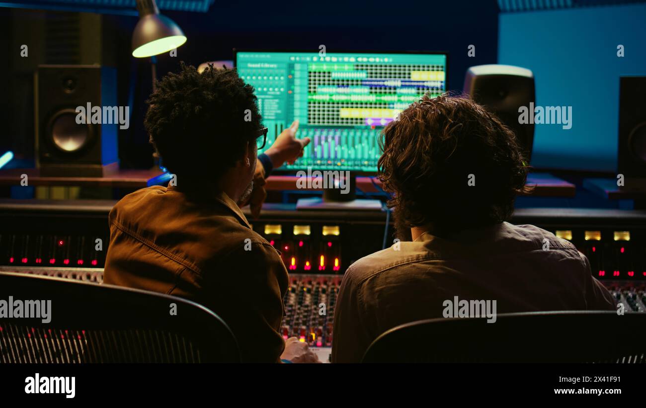 Team of sound engineers working on recording and editing tracks in ...