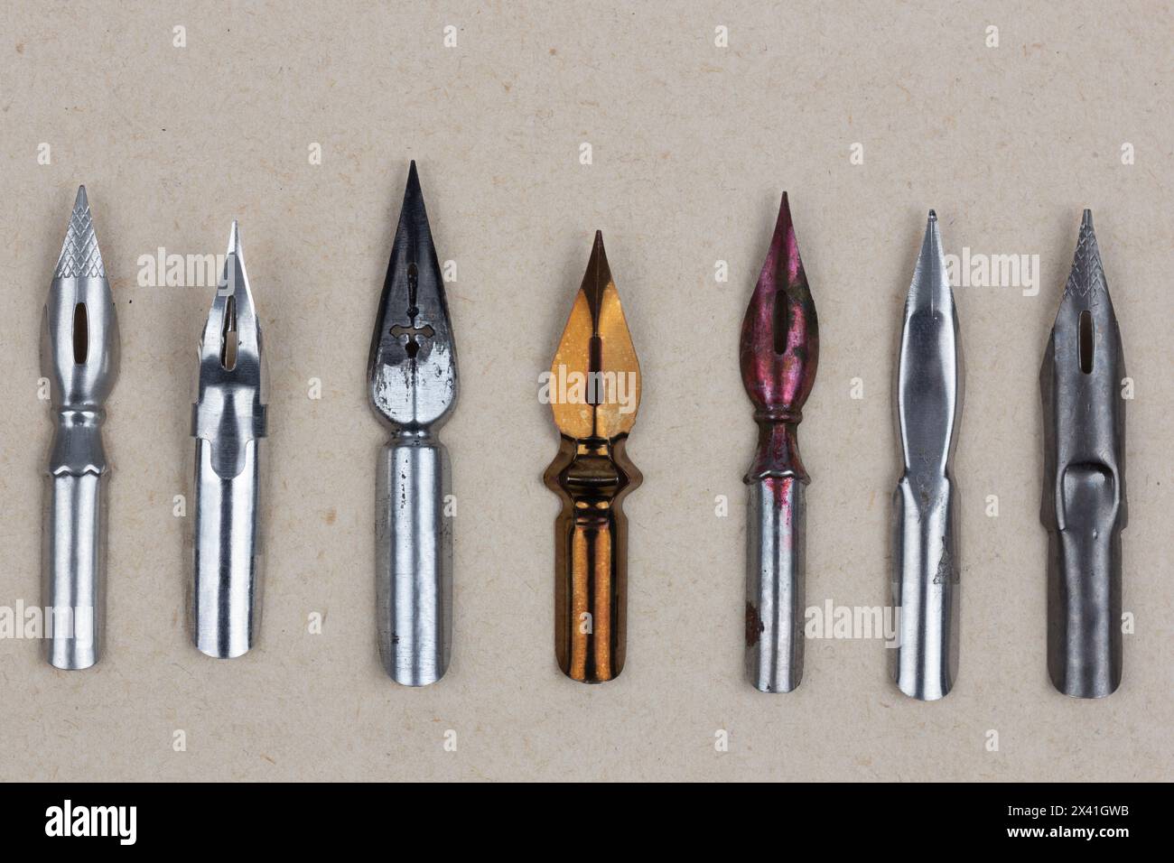 Metal nibs on an antique textured paper background Stock Photo - Alamy
