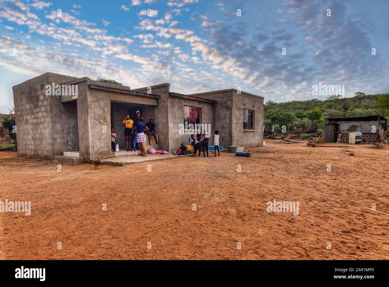 african village, large family gathered together on the house porch view ...