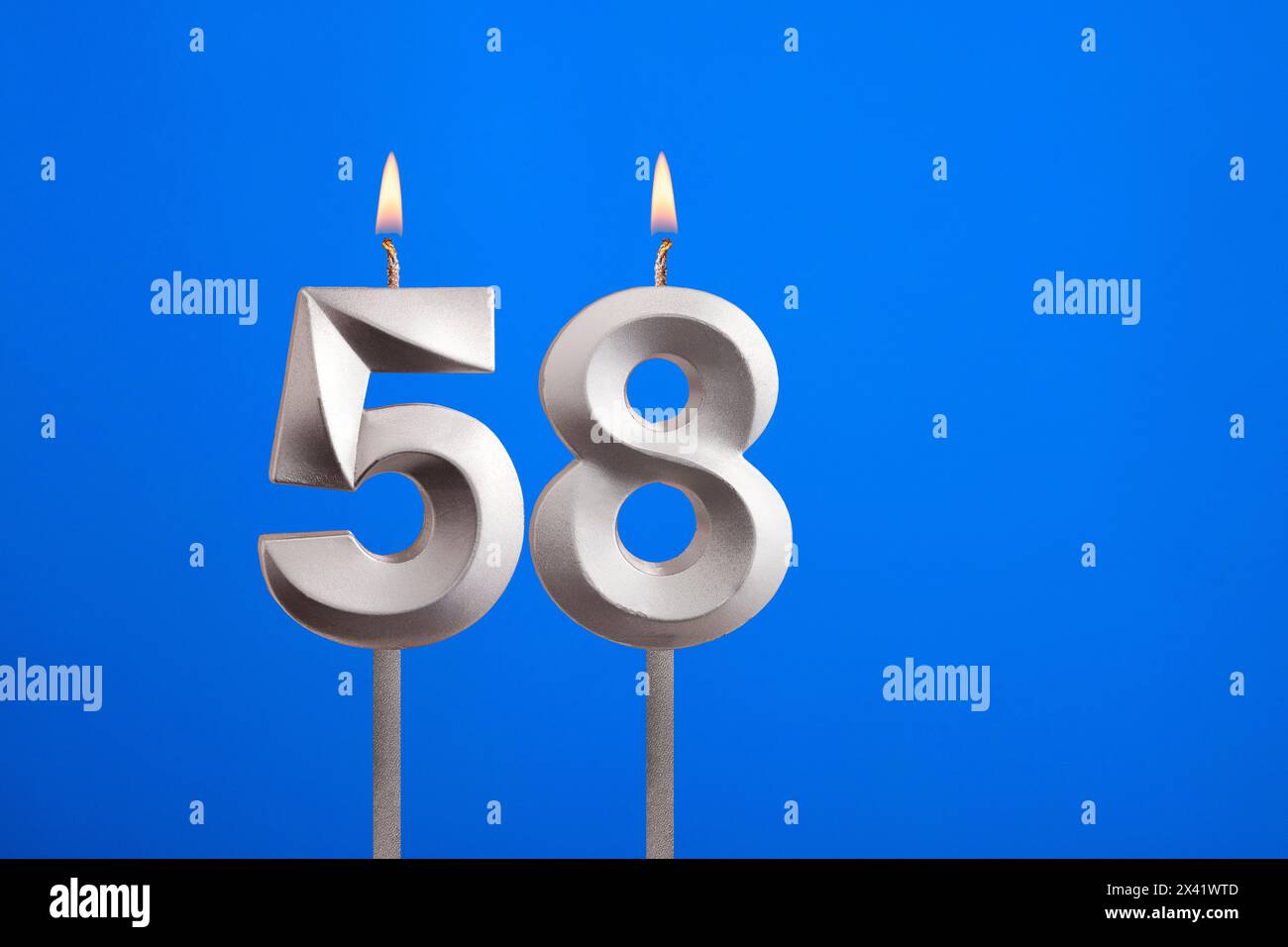 Birthday number 58 - Candle lit on blue background Stock Photo - Alamy