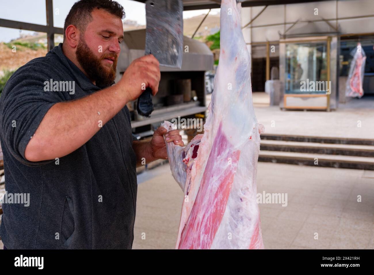 Bearded man cutting meat for poor peoples during eid in butchery Stock ...