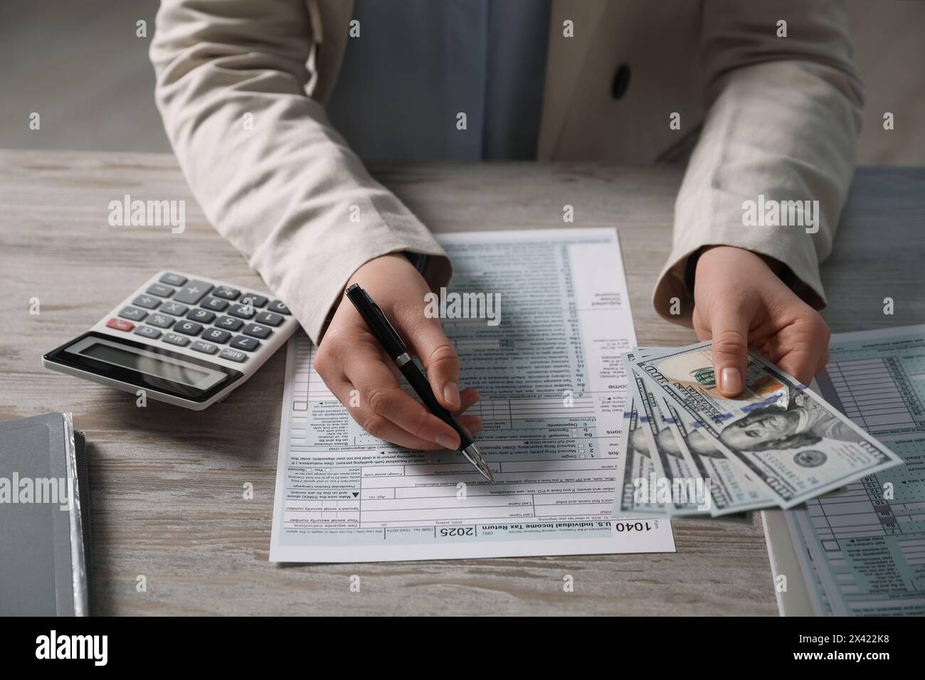 Payroll. Woman with dollar banknotes working with tax return forms at ...