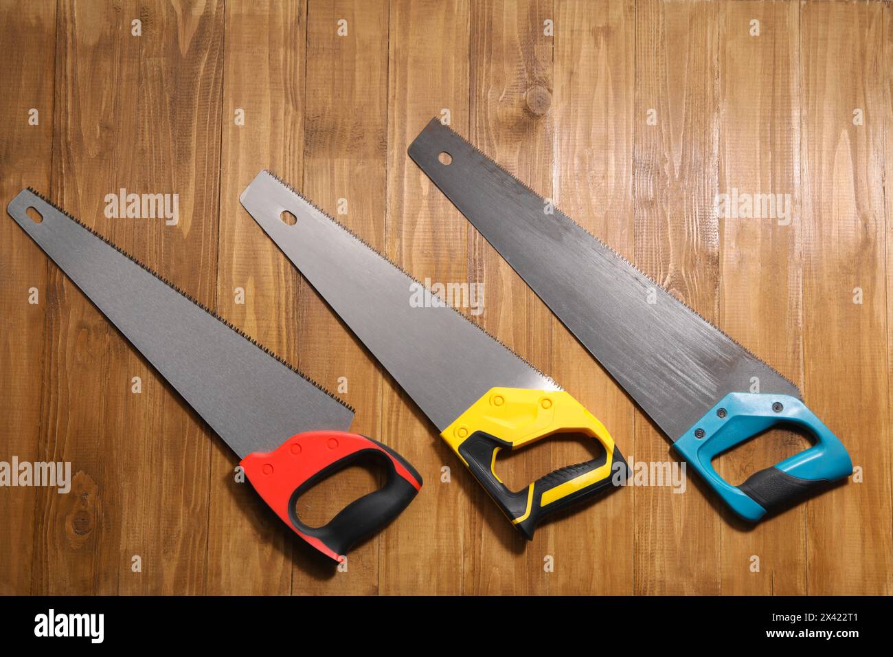 Saws with colorful handles on wooden background, flat lay Stock Photo ...