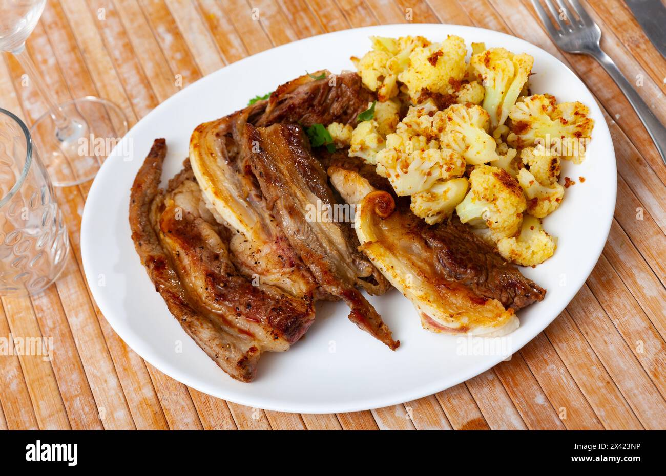 Fried lamb served with cauliflower on platter Stock Photo - Alamy