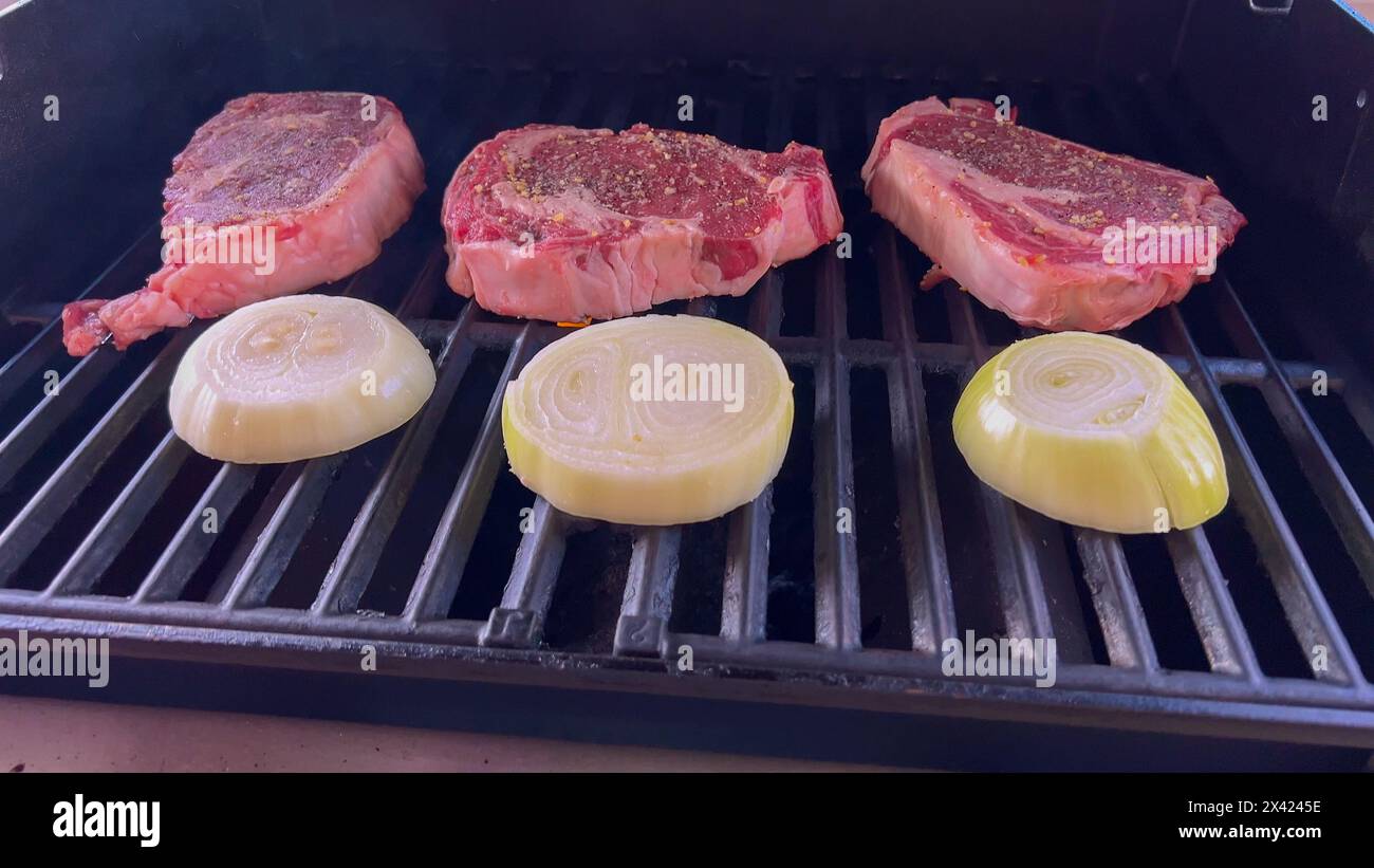 Summer Barbecue with Ribeye Steaks and Grilled Onions on the Grill ...