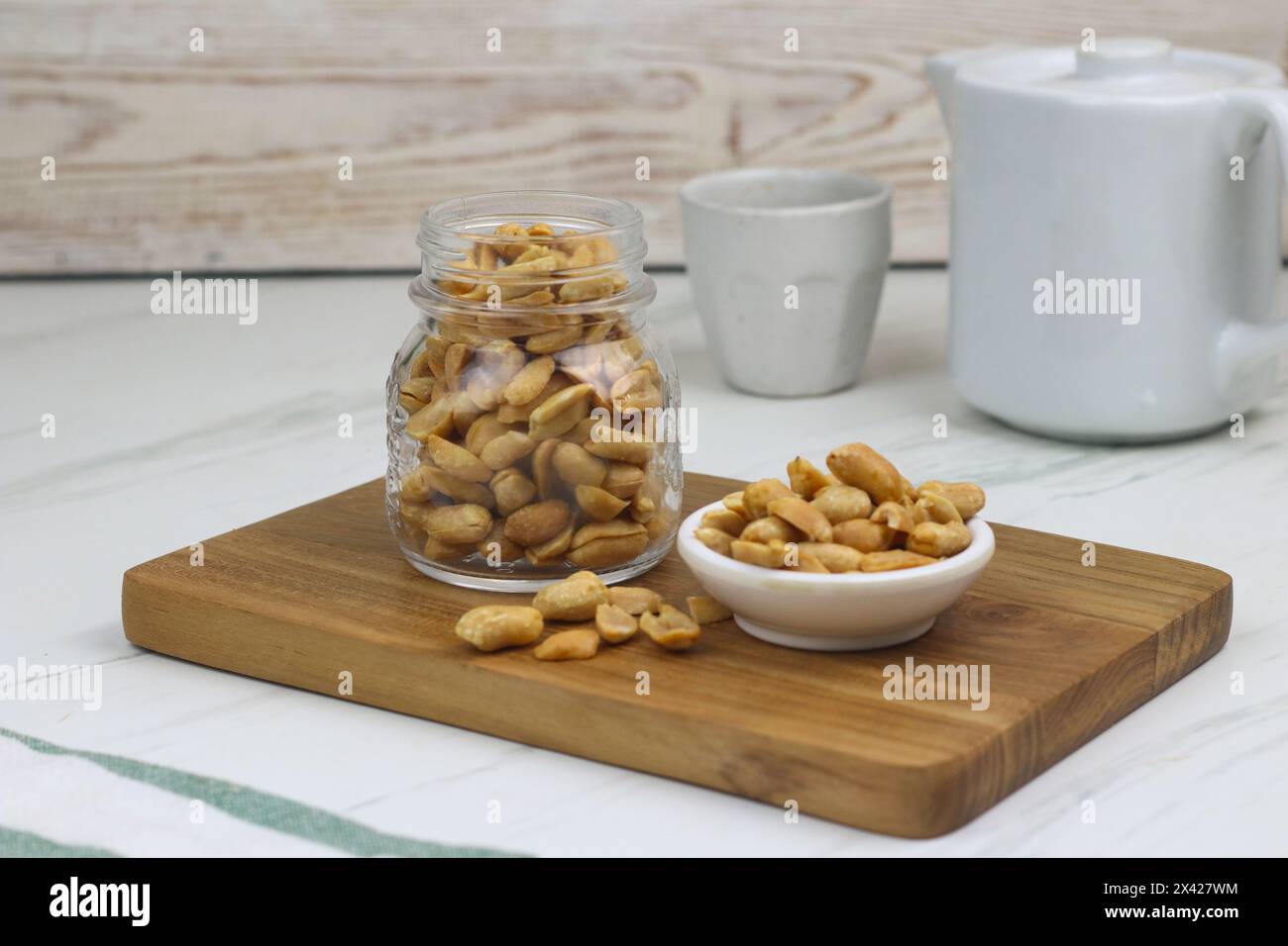 Kacang goreng or fried peanuts in a jar and white plate. Indonesian ...