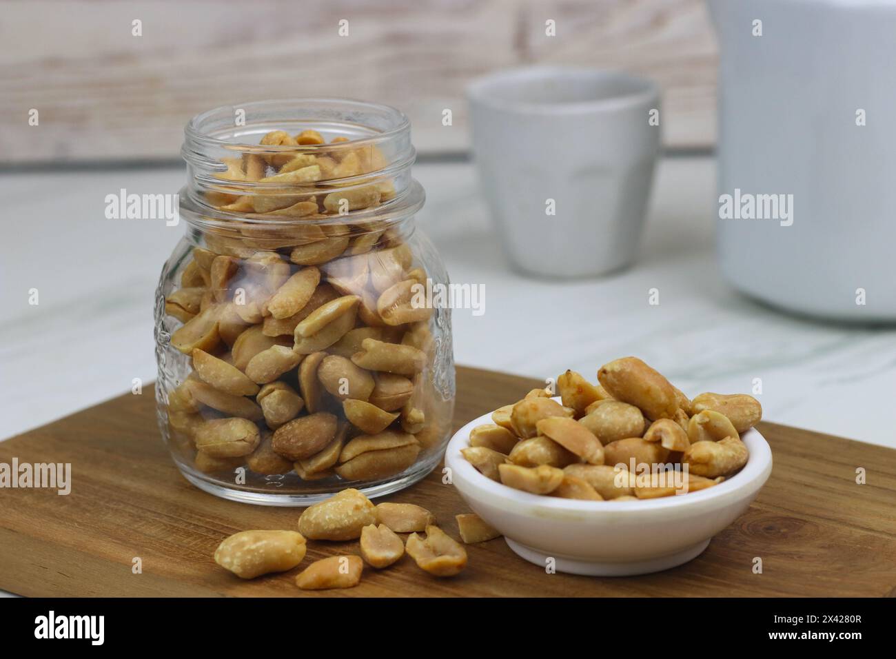 Kacang goreng or fried peanuts in a jar and white plate. Indonesian ...