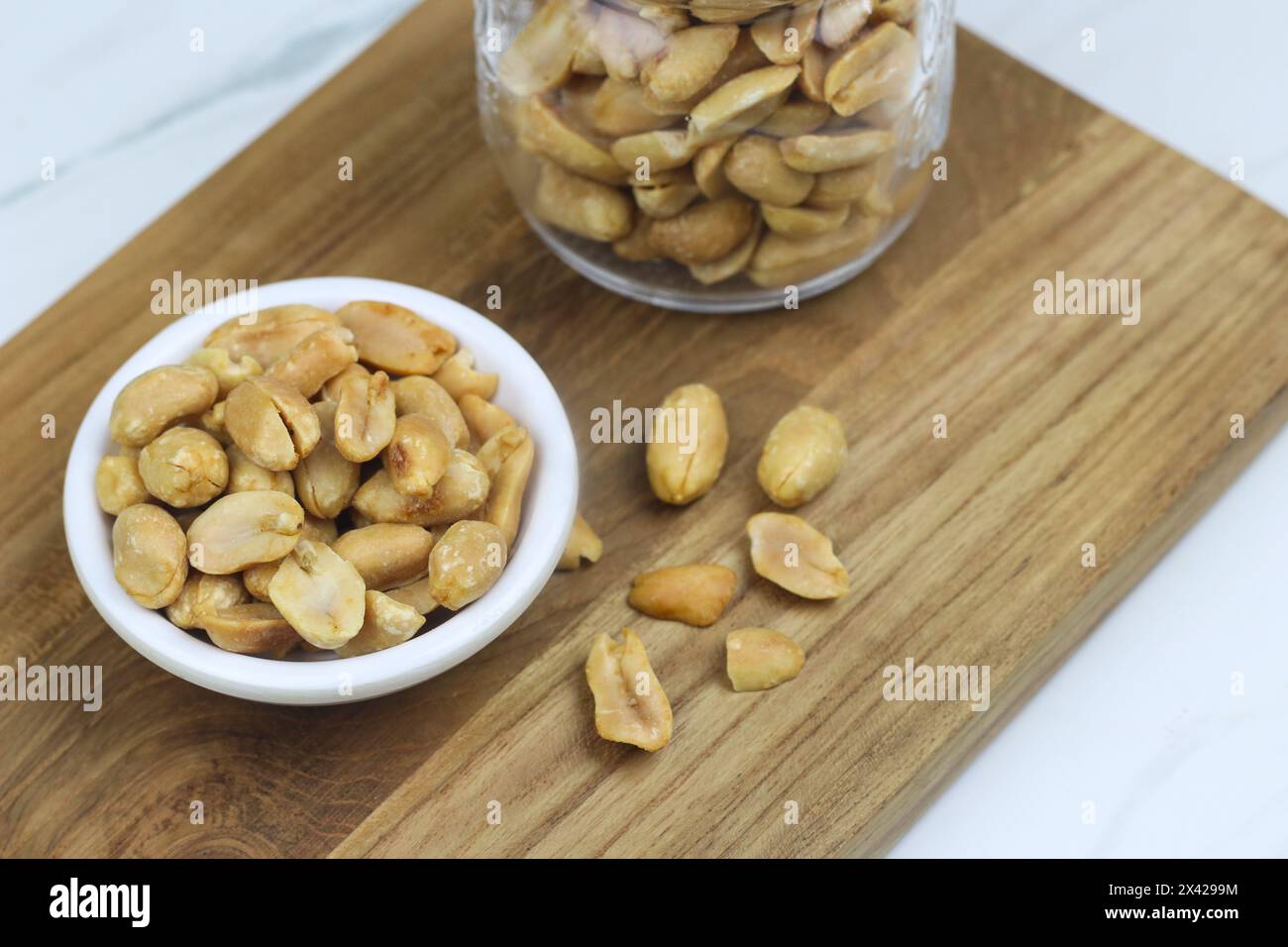 Kacang goreng or fried peanuts in a jar and white plate. Indonesian ...