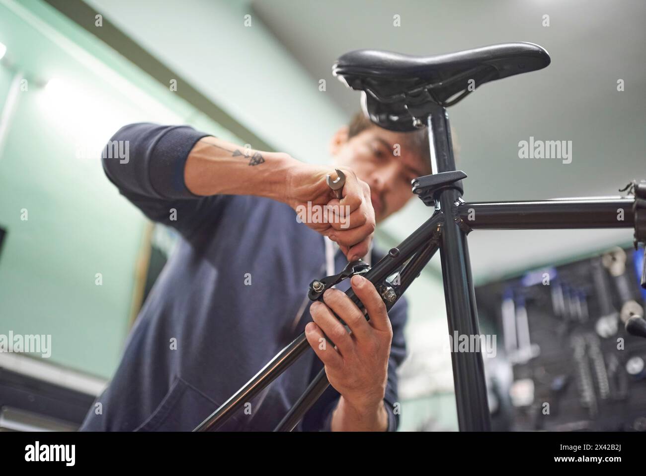 Hispanic man assembling the brake system of a bicycle as part of the ...