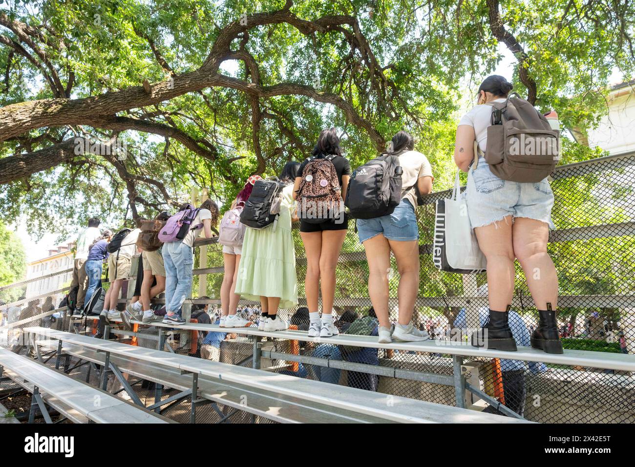 Austin, Texas, USA. April 29, 2024. Students wearing backpacks watch ...