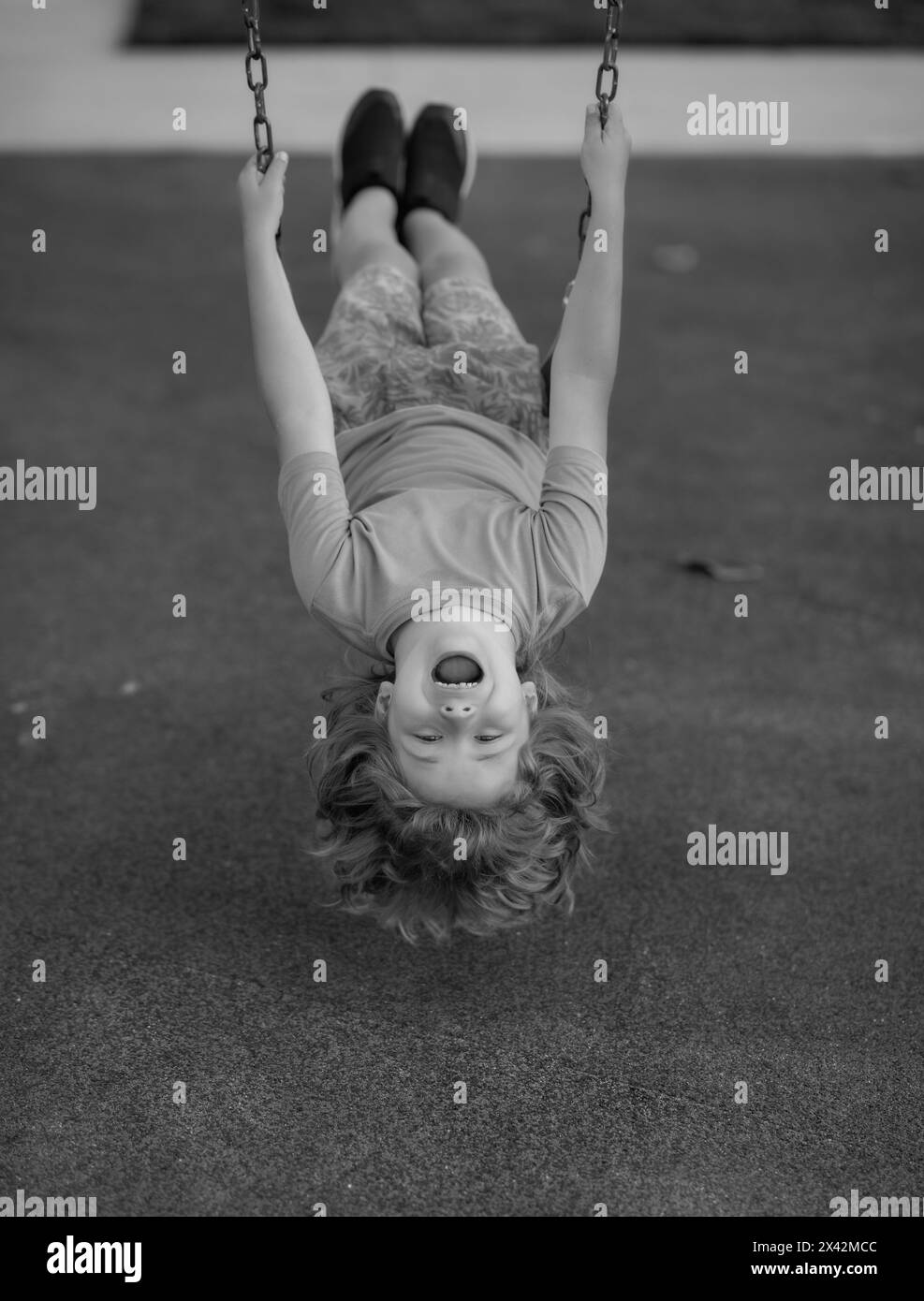 Child on swing playing on outdoor playground. Child boy exercise at playground. Cute kid having ...