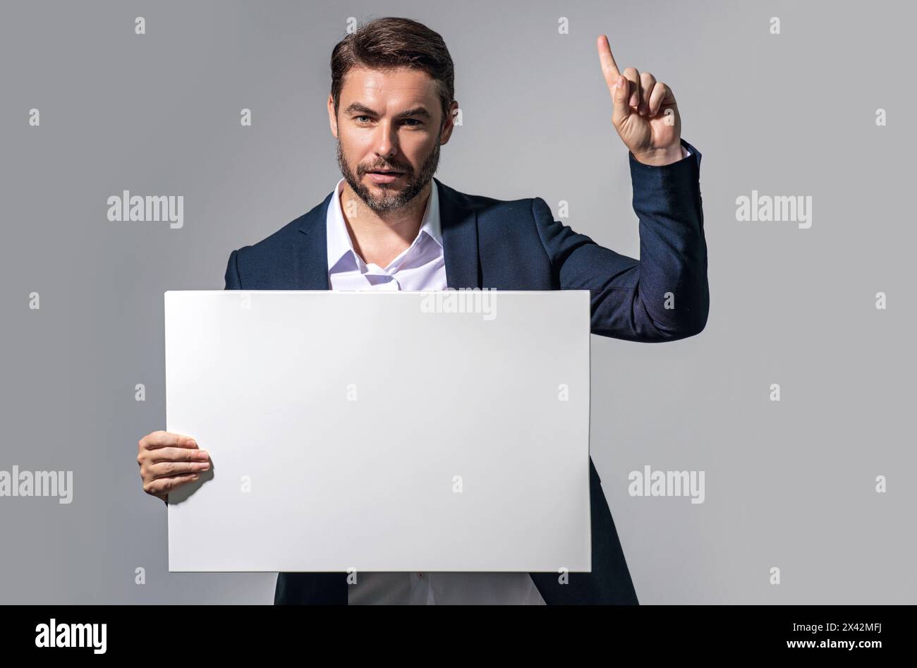 Happy man hold board thinking of idea on studio background. Portrait of ...
