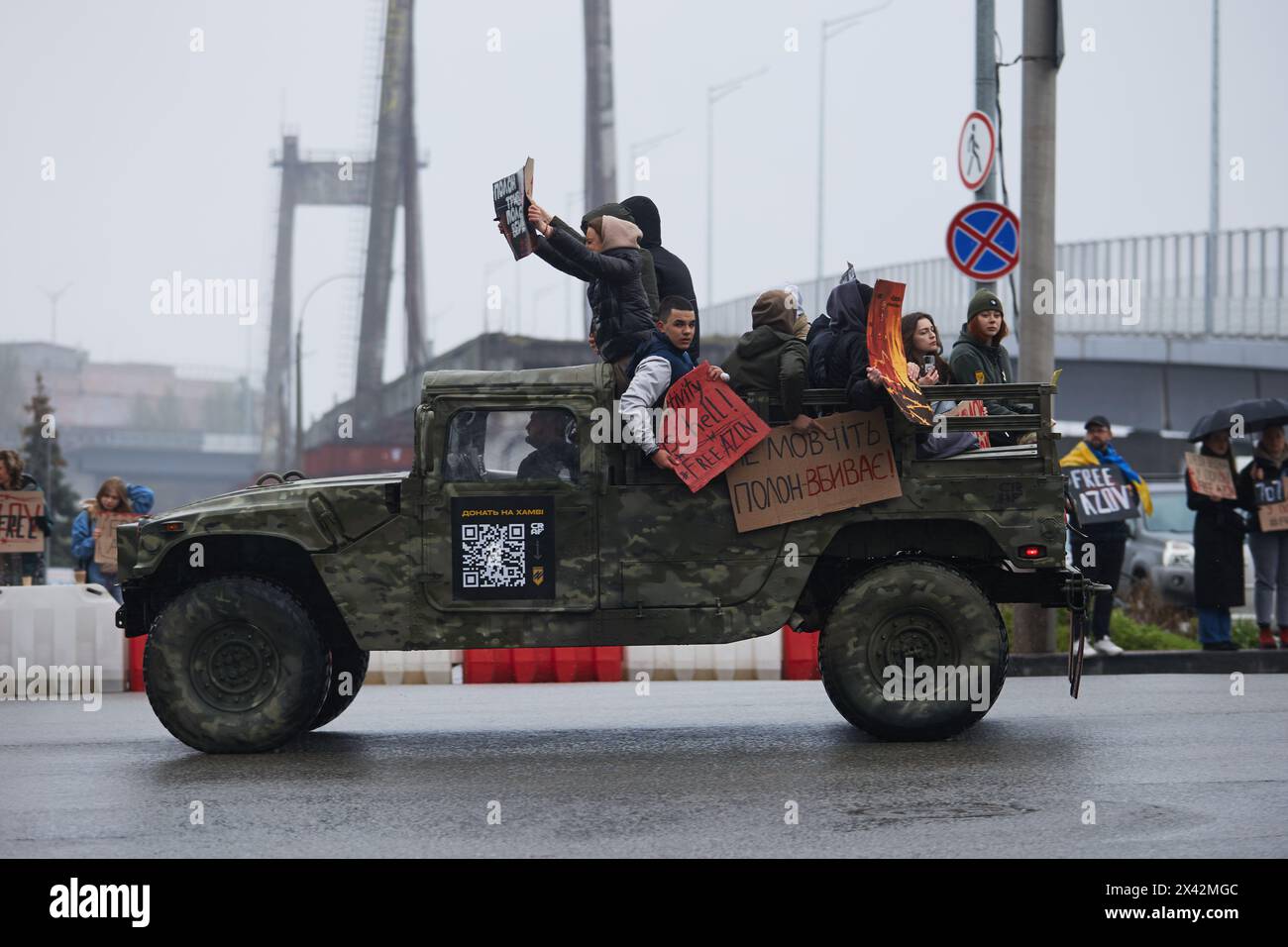 Ukrainian activists riding on a military HMMW Hummer truck with banners ...