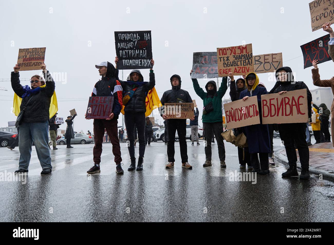 Group of Ukrainian activists posing with banners "Free Azov" and ...