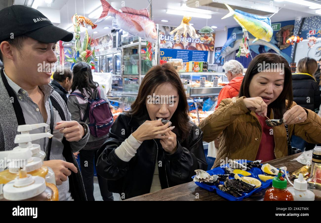 Customers eat oysters in the food hall of the South Melbourne market ...