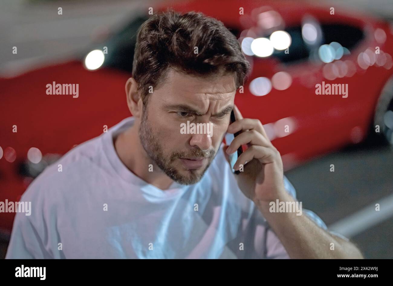 Gangster, criminal concept. Angry man near car on night urban street ...