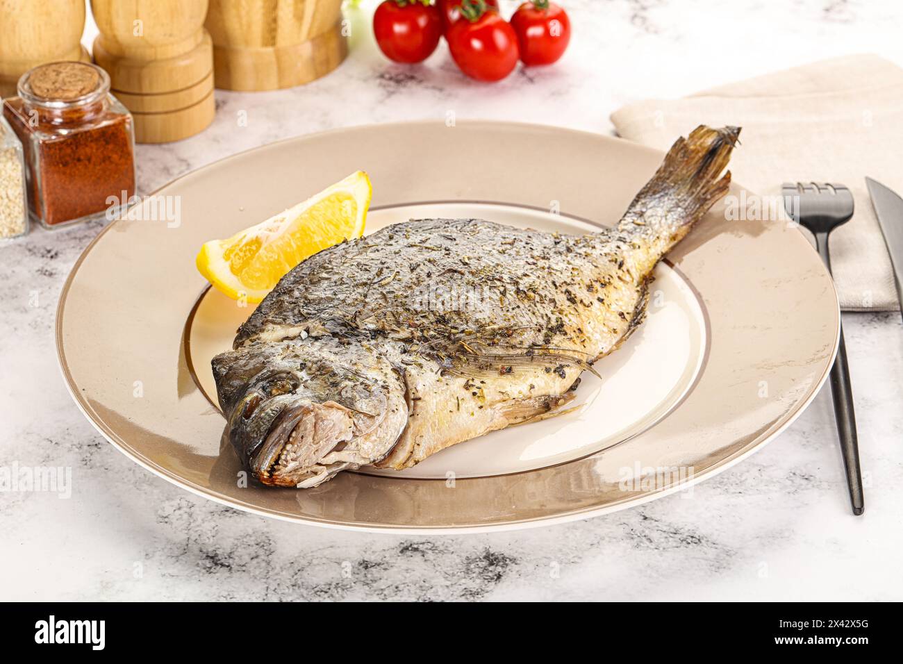 Baked Dorado fish served lemon slice Stock Photo - Alamy