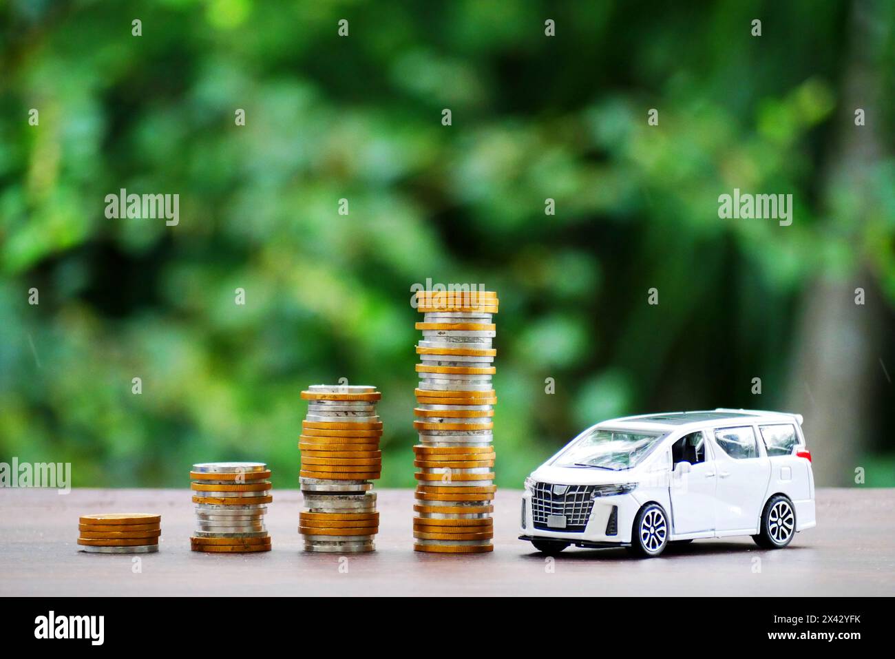 Pile of coins, toy cars on table. Concept of saving and managing money ...