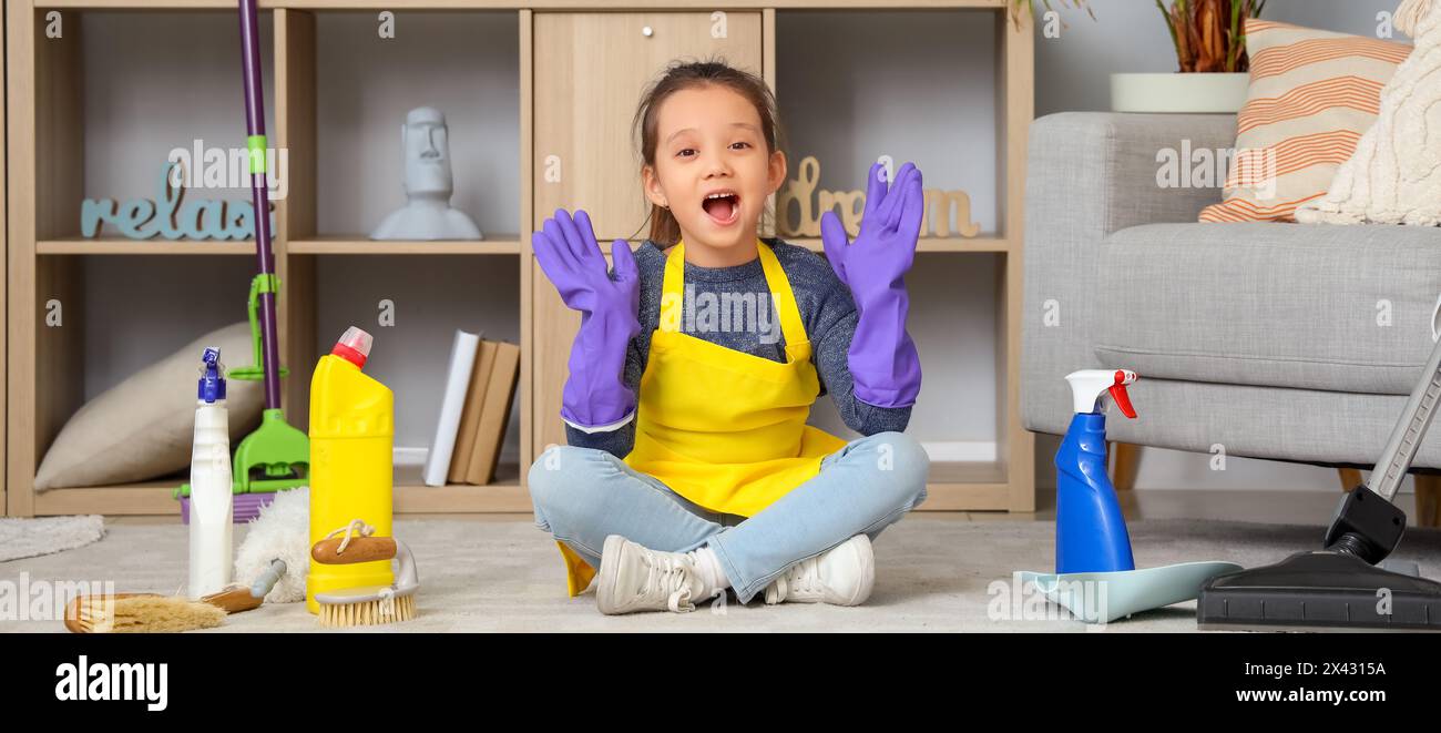 Cute little girl with cleaning supplies at home Stock Photo - Alamy