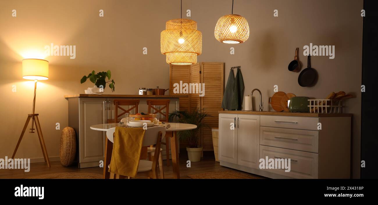 Interior of stylish kitchen with glowing lamps at night Stock Photo - Alamy