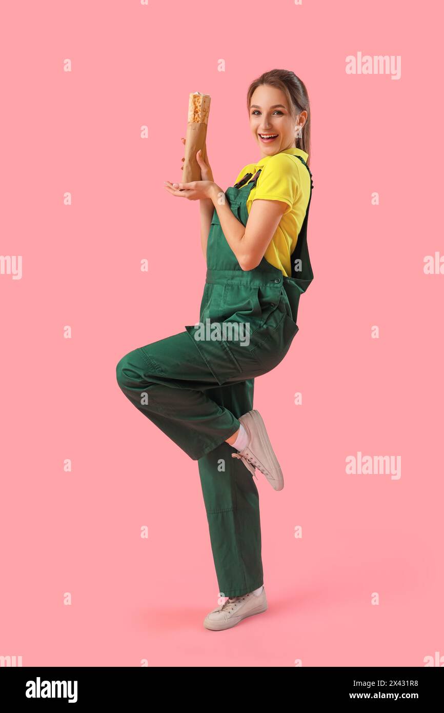 Female courier with doner kebab on pink background Stock Photo - Alamy