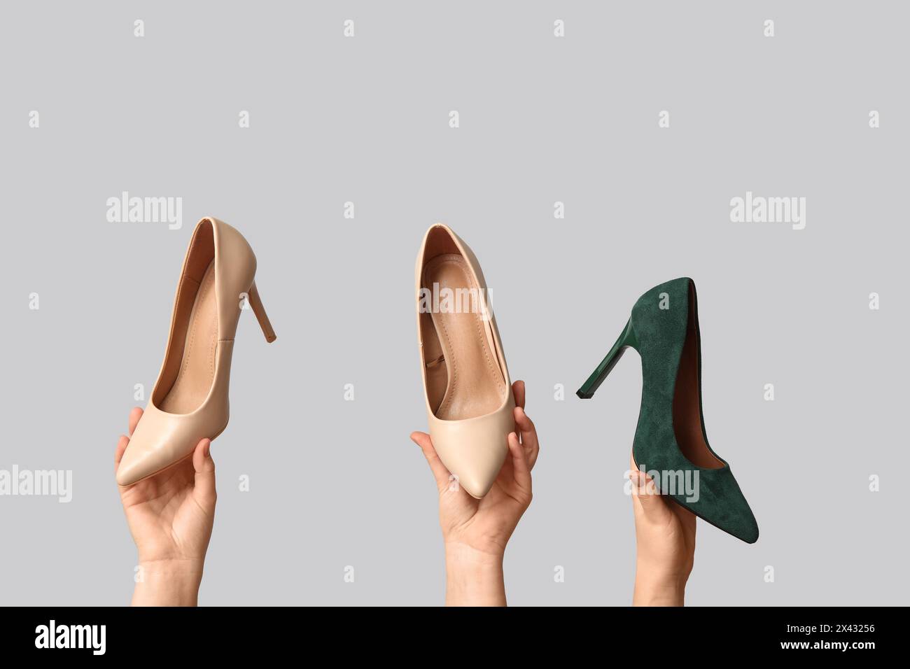 Female hands with different stylish high heels on grey background Stock ...