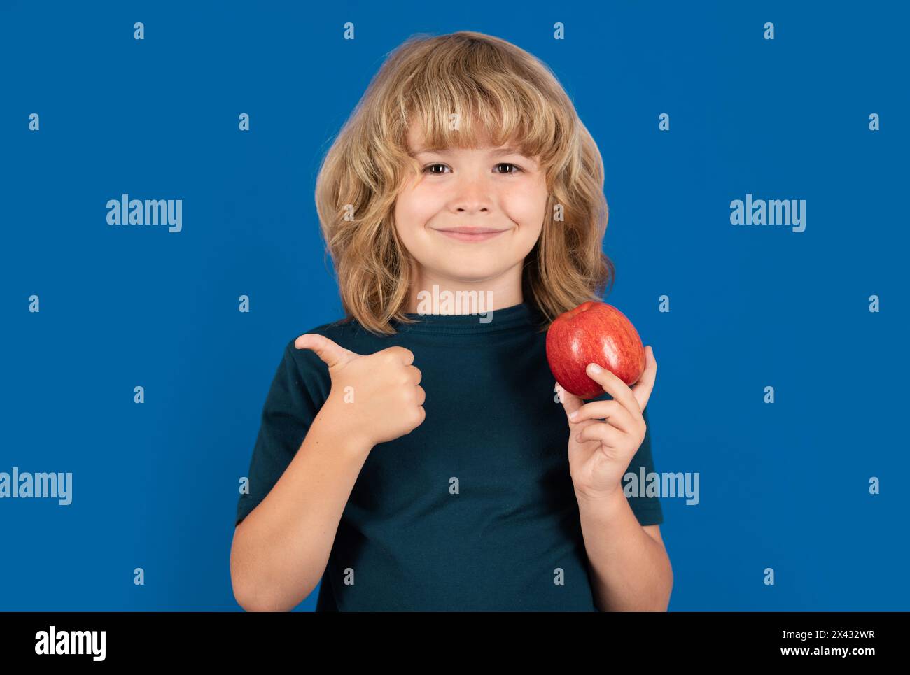 Healthy eating. Smiling child with thumbs up hold apple. Portrait of of ...