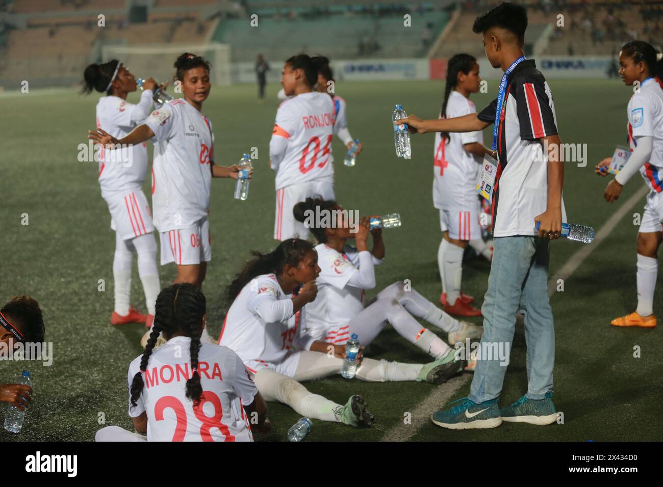 Dhaka Rangers FC players sip water during a cooling break to avoid overheating during the UCB ...