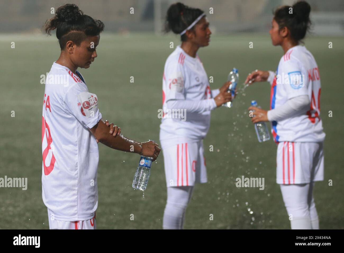 Dhaka Rangers FC players sip water during a cooling break to avoid overheating during the UCB ...