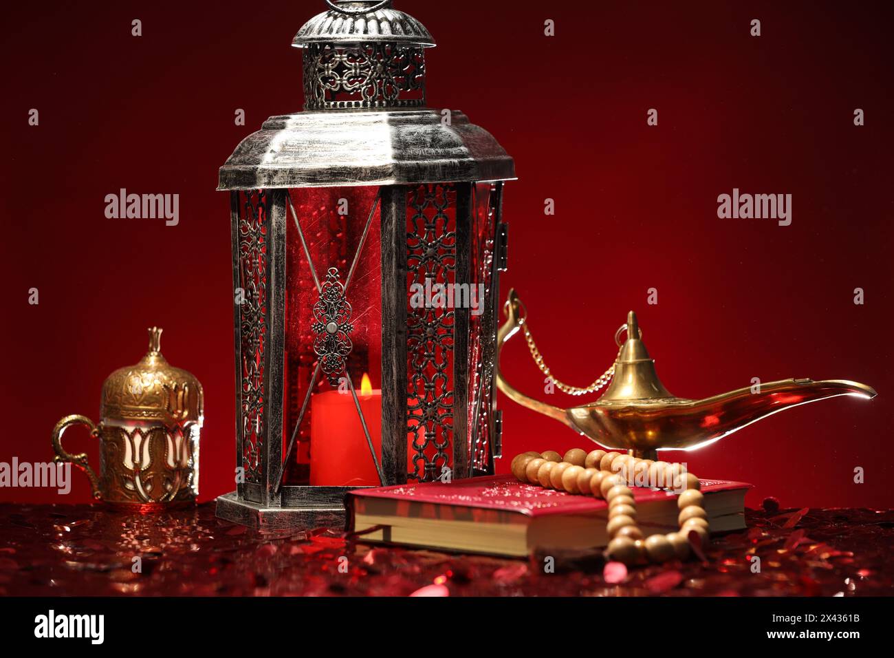 Arabic lantern, Quran, misbaha and Aladdin magic lamp on shiny red ...